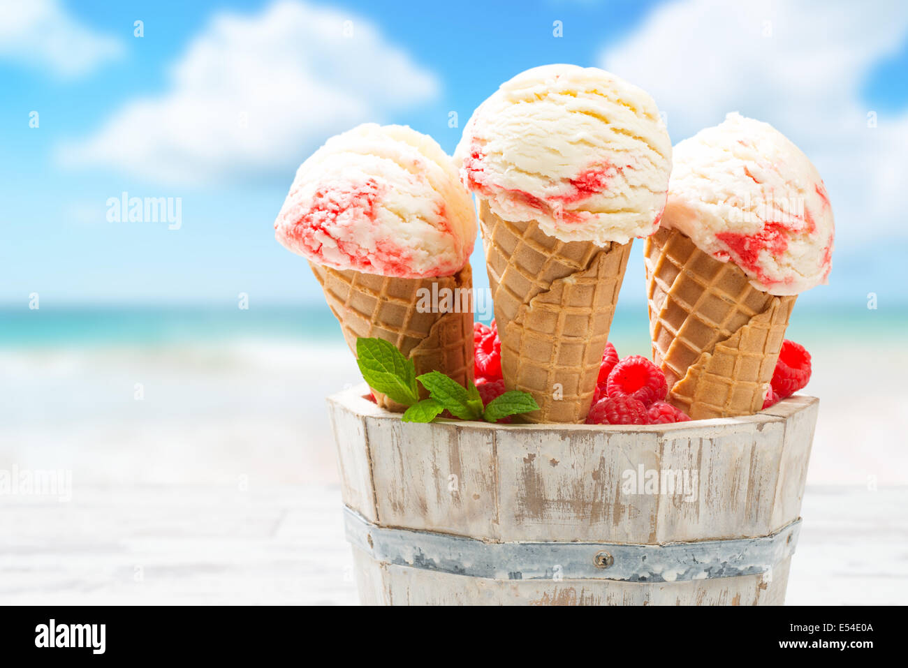 Close up of raspberry ripple ice creams with beach blur background ...