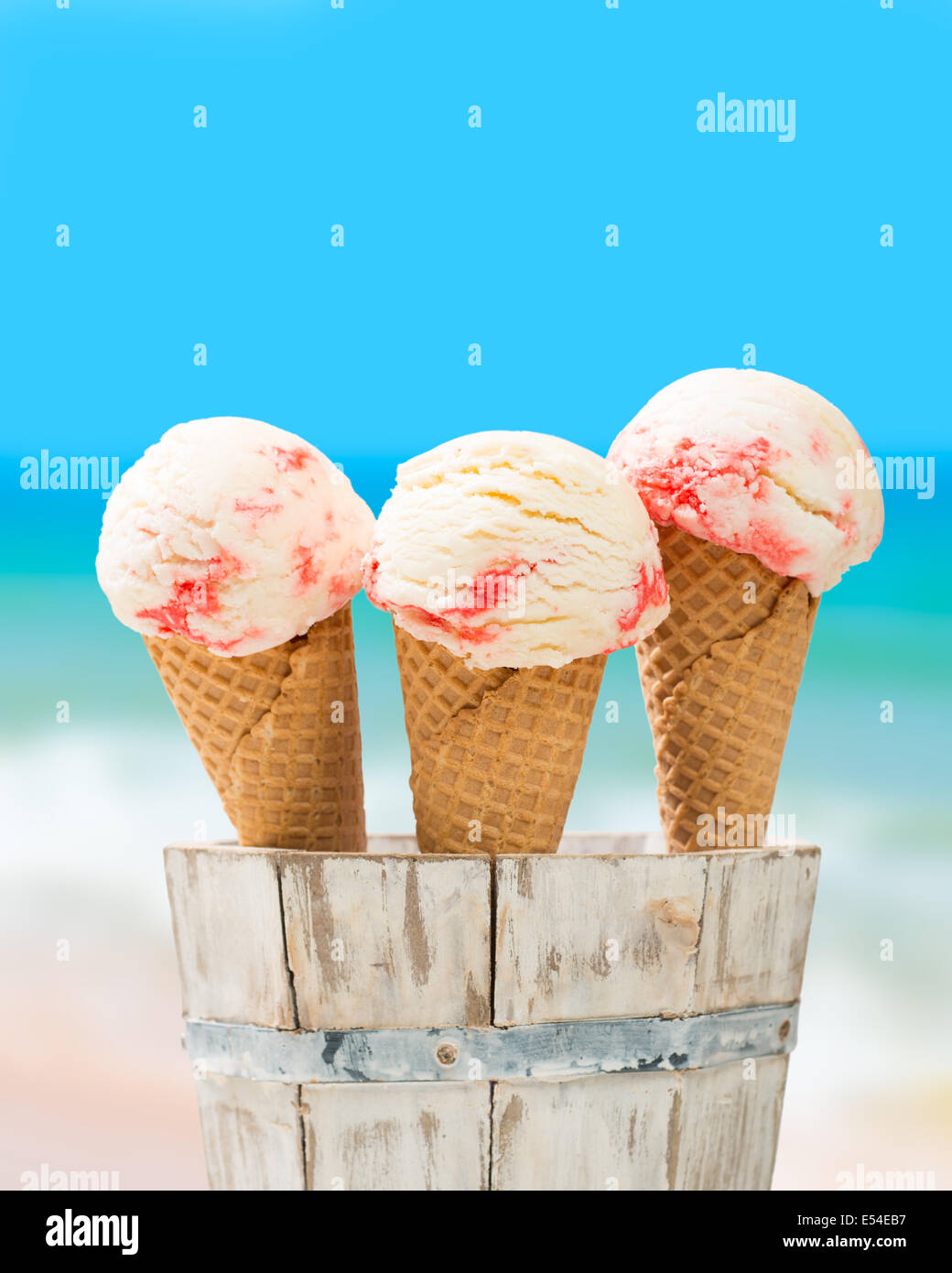 Three raspberry ripple icecreams with beach blur background Stock Photo ...