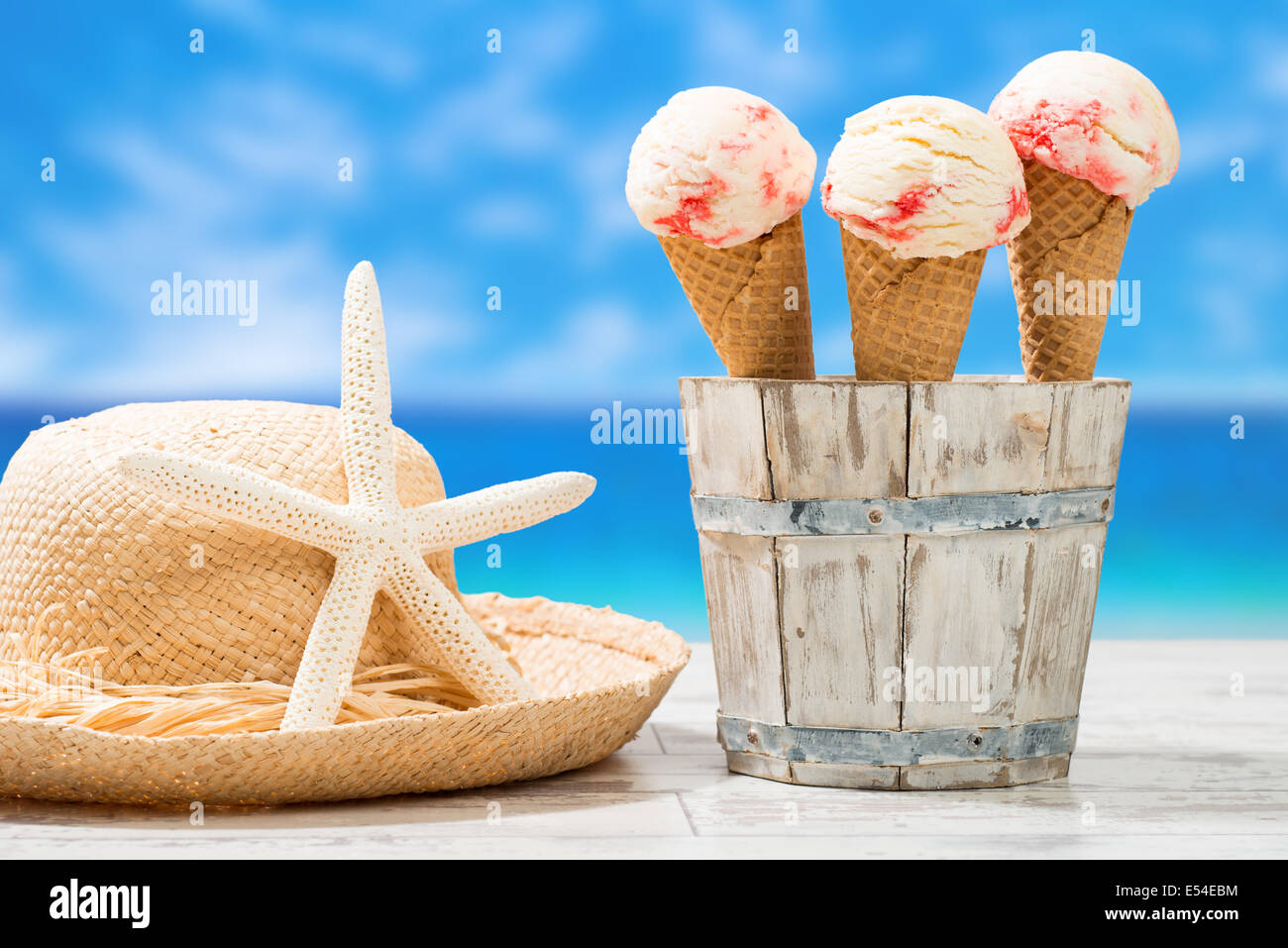 Raspberry ripple ice creams with sun hat and beach blur background ...