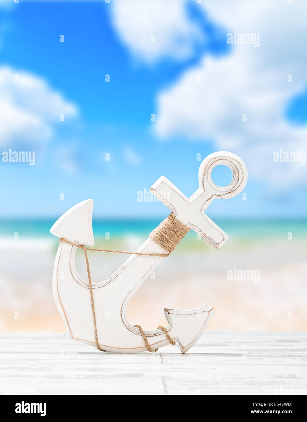 Wooden ships anchor on rustic wooden decking with beach blur background ...