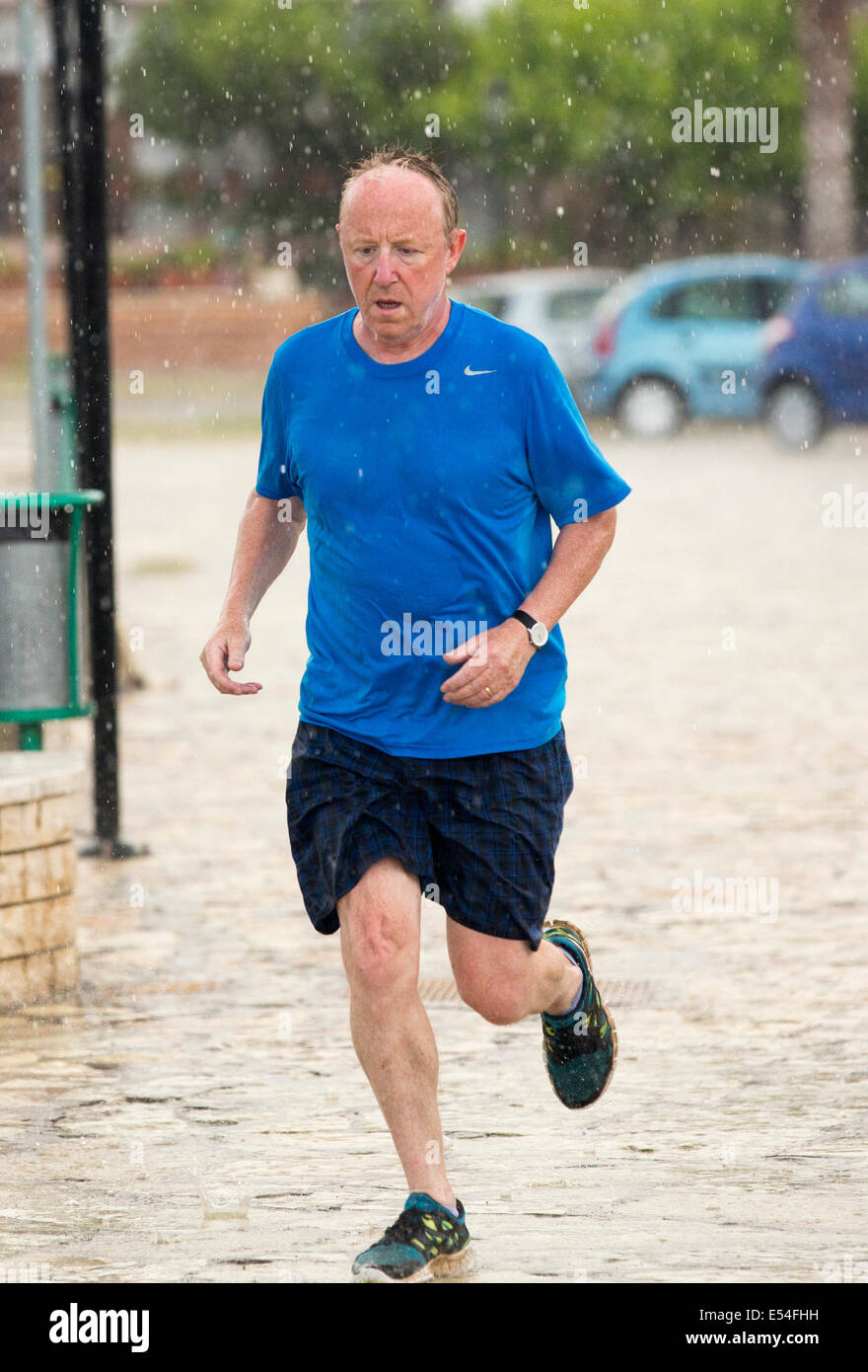 A man running through torrential rain and hail from a thunderstorm in ...
