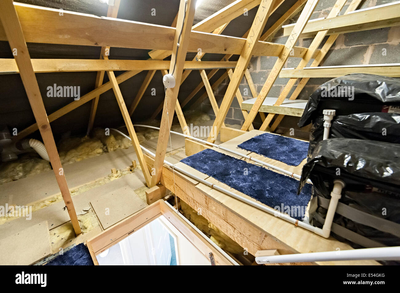 a partially boarded loft for storage in a modern house with shelving ...