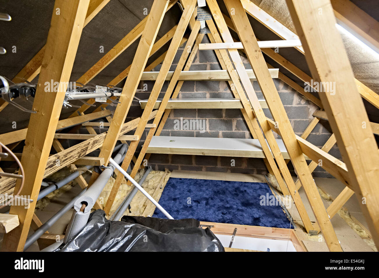 a partially boarded loft for storage in a modern house with shelving ...
