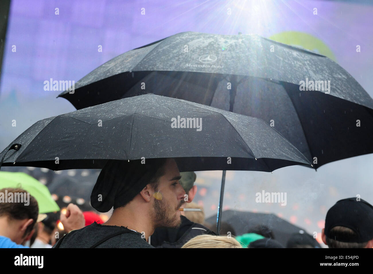 Freiburg, Germany. 20th July, 2014. Techno fans with umbrellas during ...