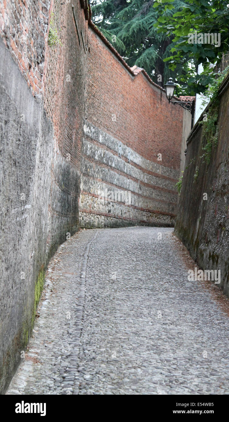 cobblestone lane with bounded by high walls of brick Stock Photo - Alamy
