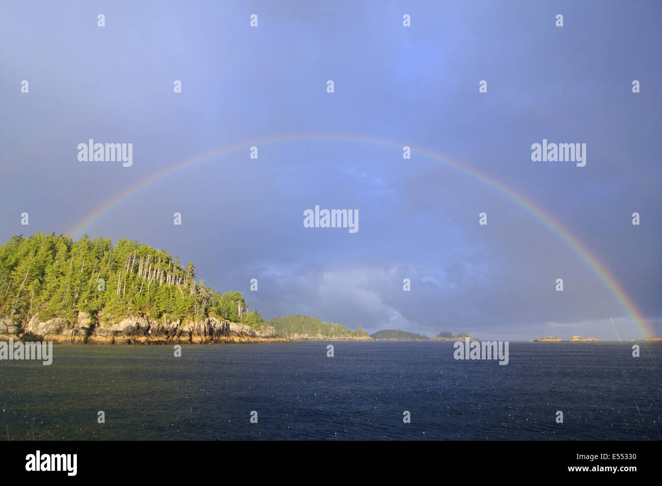 Rainbow over coastline and temperate coastal rainforest, Calvert Island ...