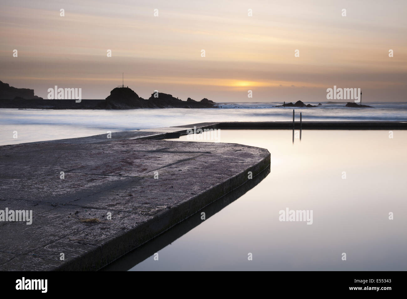 View of tidal swimming pool with incoming tide and waves breaking over ...