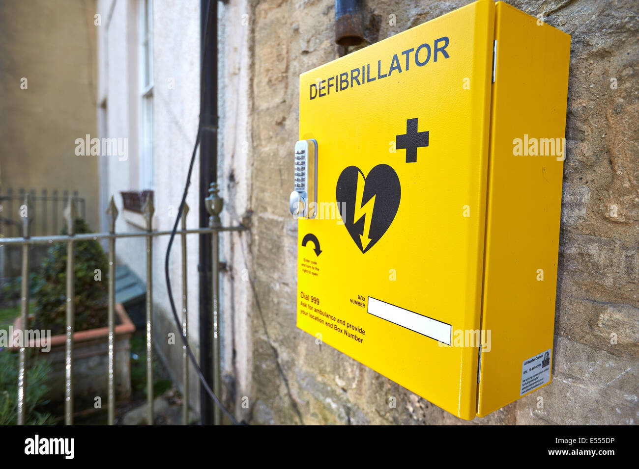 Automated external defibrillator installed on a stone wall on a street ...