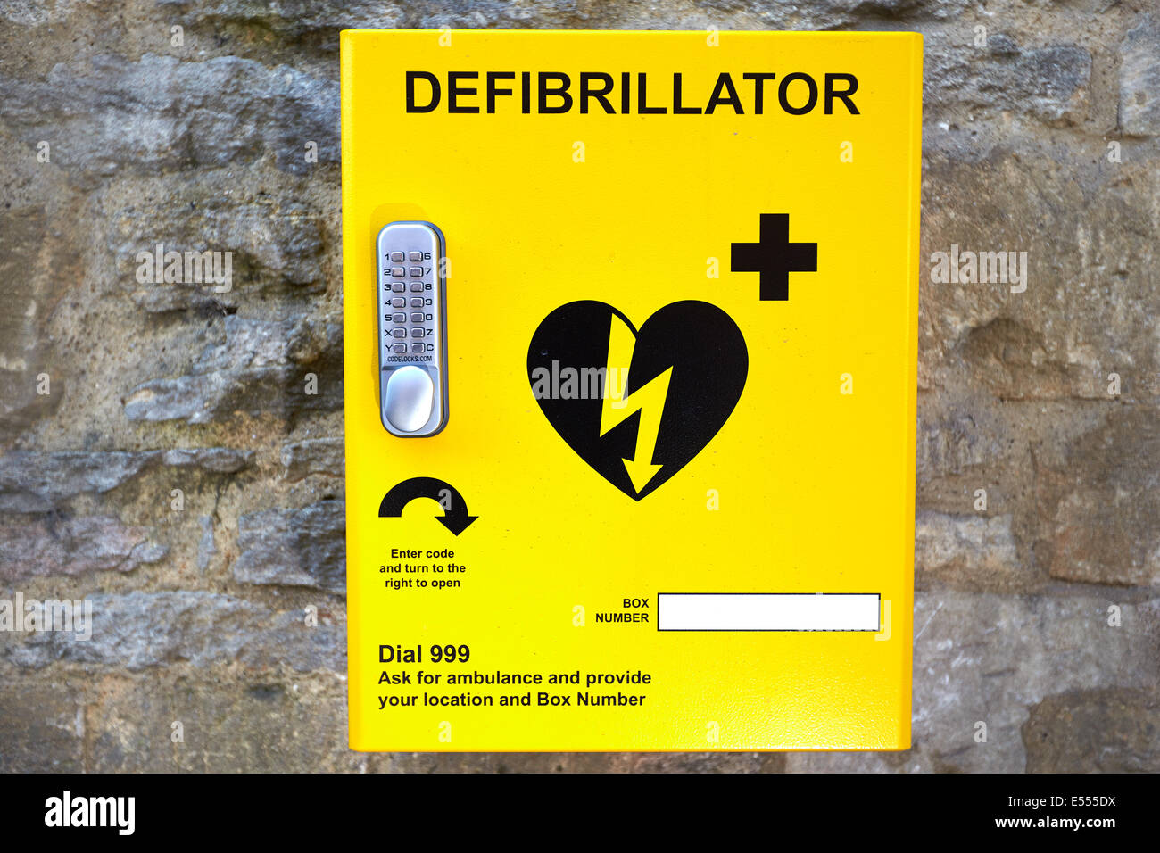Automated external defibrillator installed on a stone wall on a street ...