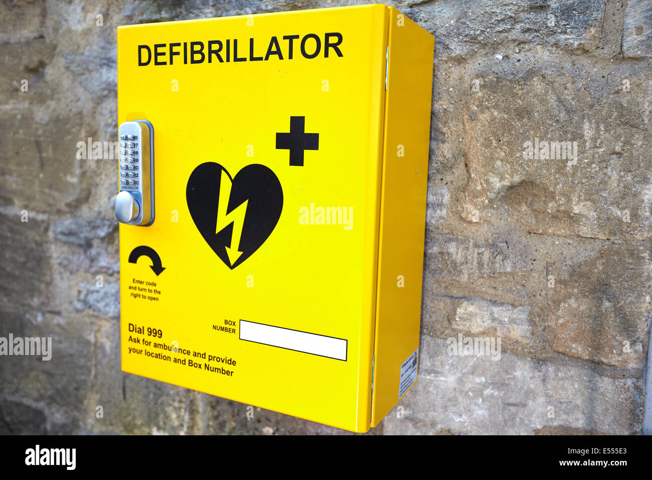 Automated external defibrillator installed on a stone wall on a street ...