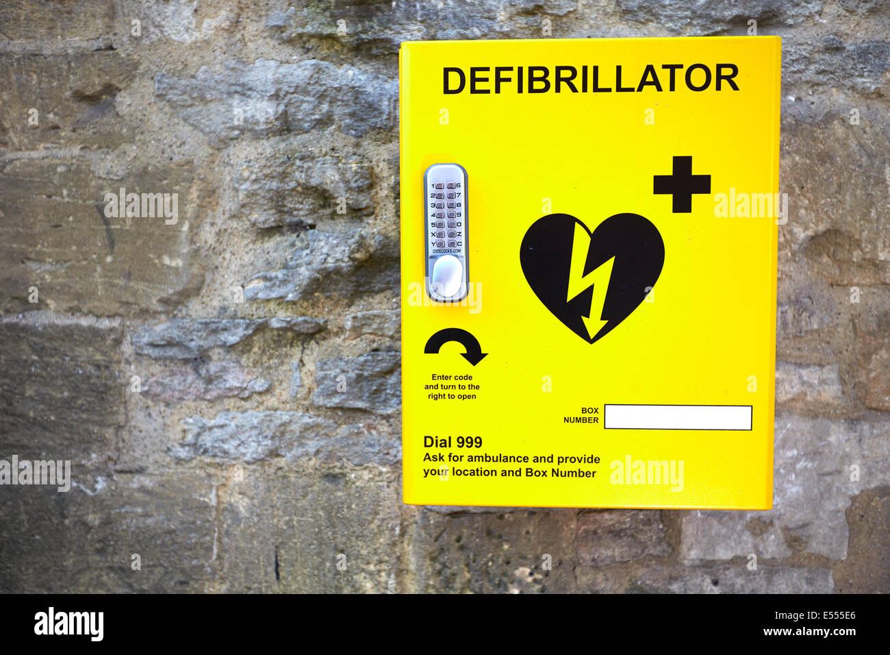 Automated external defibrillator installed on a stone wall on a street ...