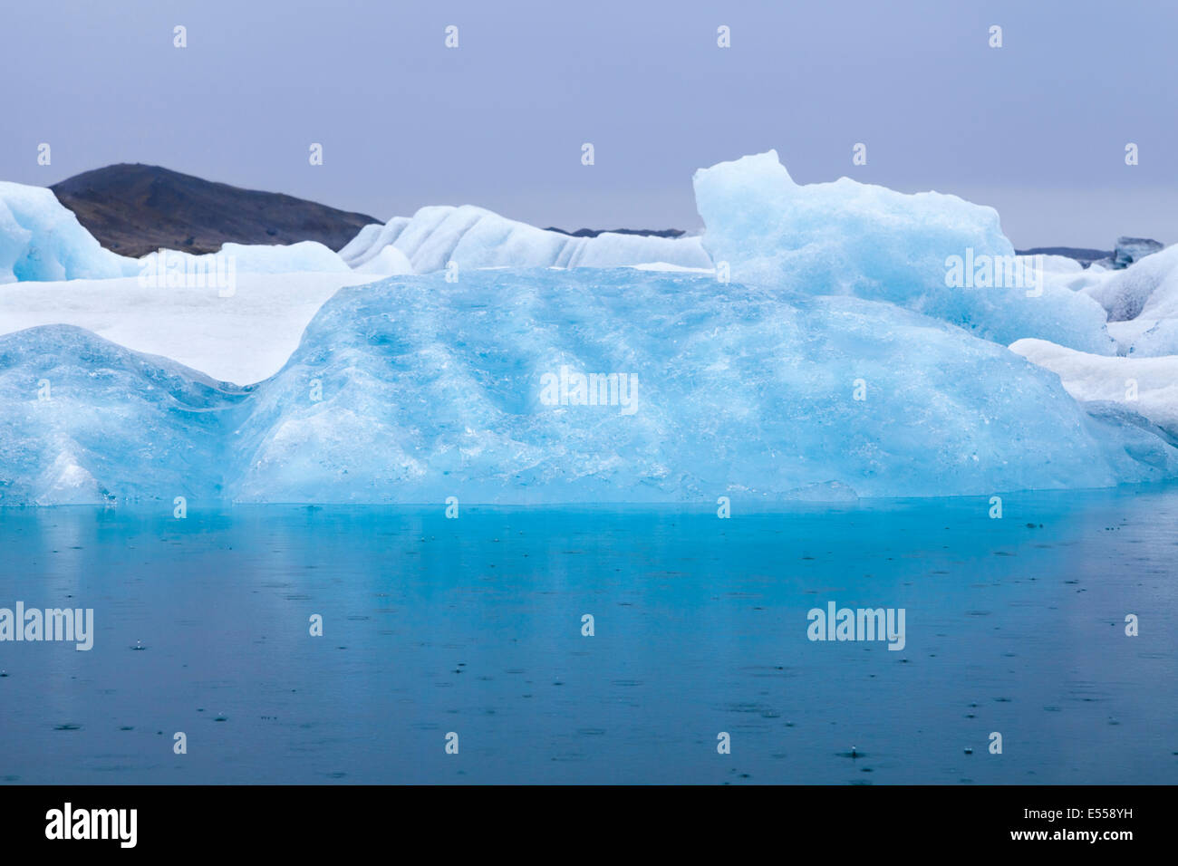 Iceberg and iridescent floating ice in the turquoise water of the ...