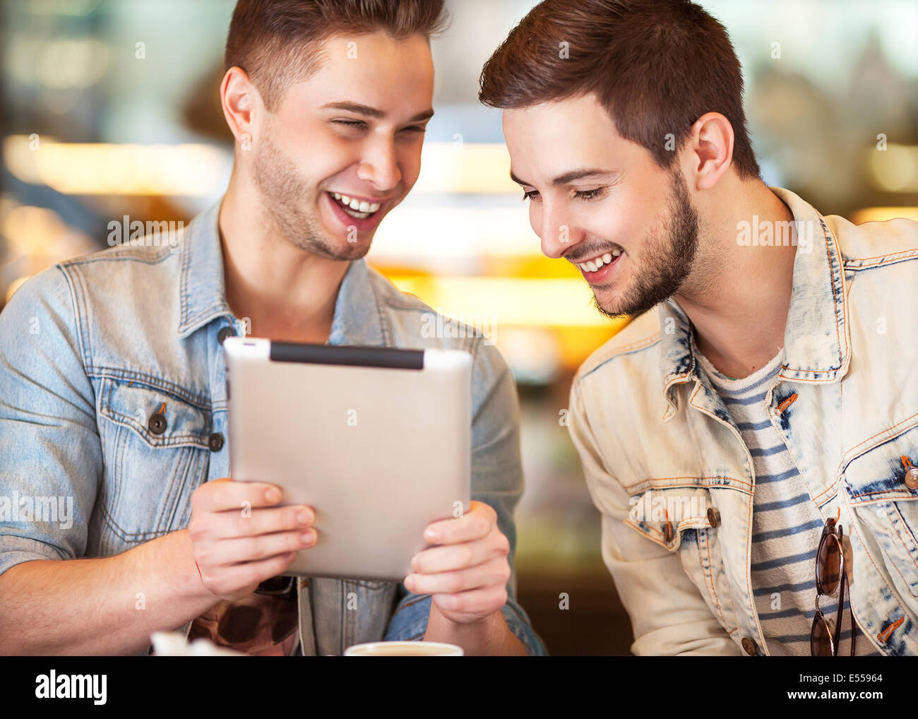 Two young men / students using tablet computer in cafe Stock Photo - Alamy