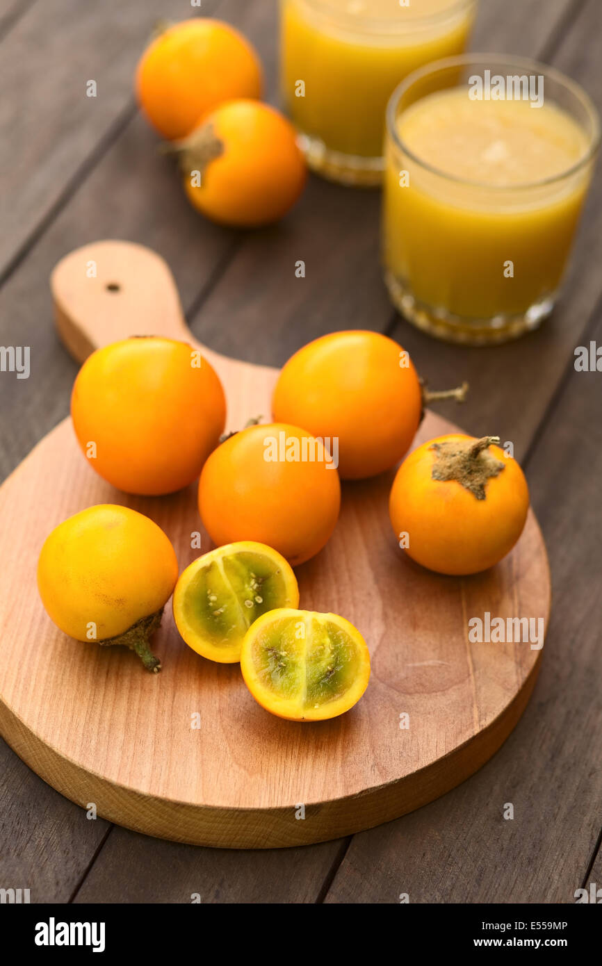 Naranjilla or Lulo fruits (lat. Solanum quitoense) on wooden board with ...
