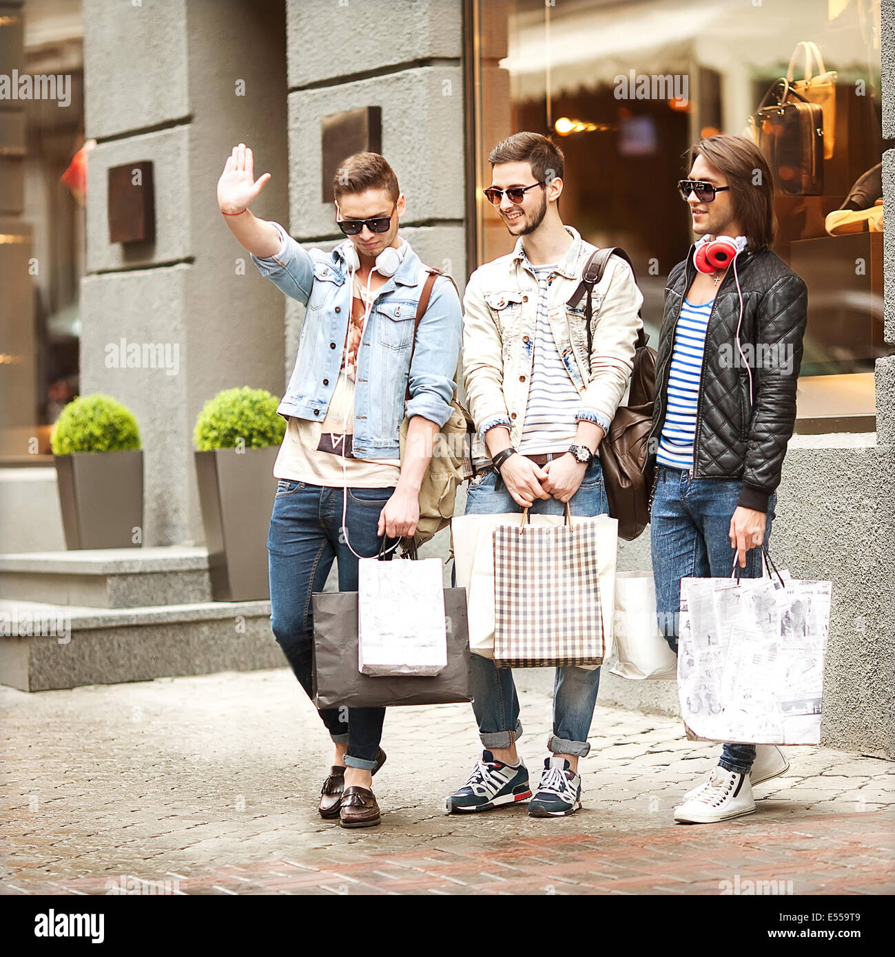 Fashion young guys go shopping with many colored shopping bags in their ...