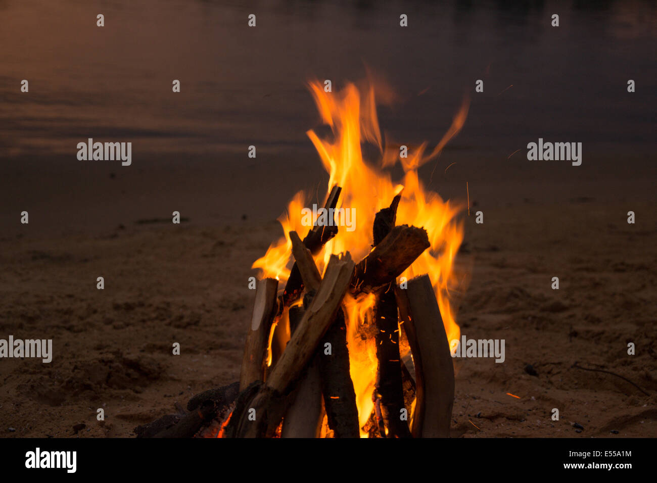 Bonfire on the sandy beach after sunset Stock Photo - Alamy