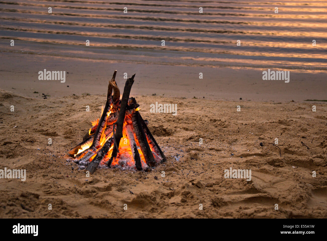 Bonfire on the sandy beach after sunset Stock Photo - Alamy