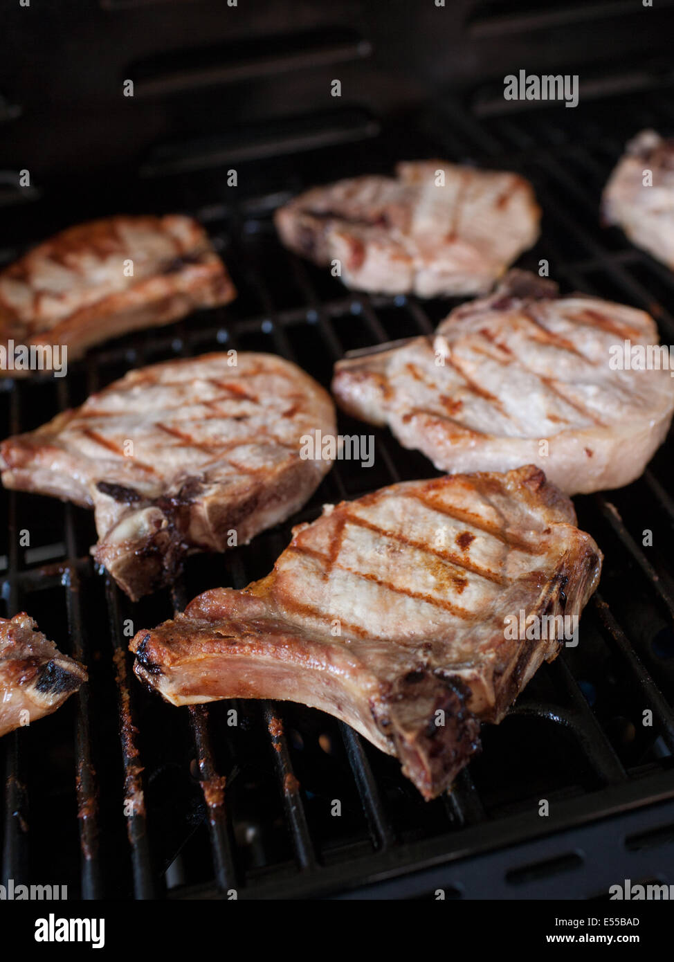 Pork Chops cooking on a grill Stock Photo - Alamy