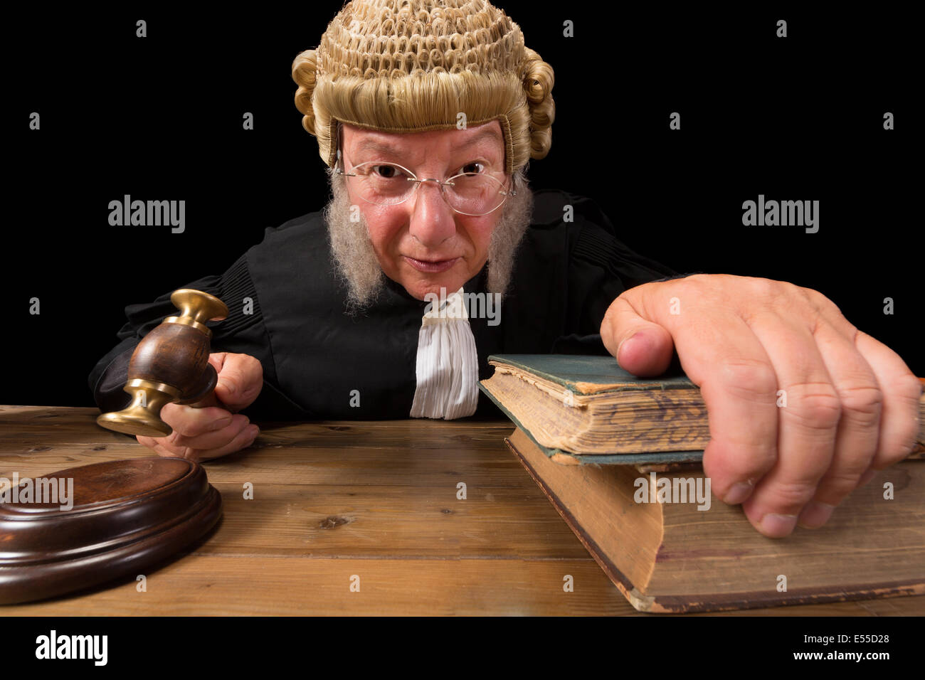 Wide angle closeup of a mature judge with authentic court wig holding a ...