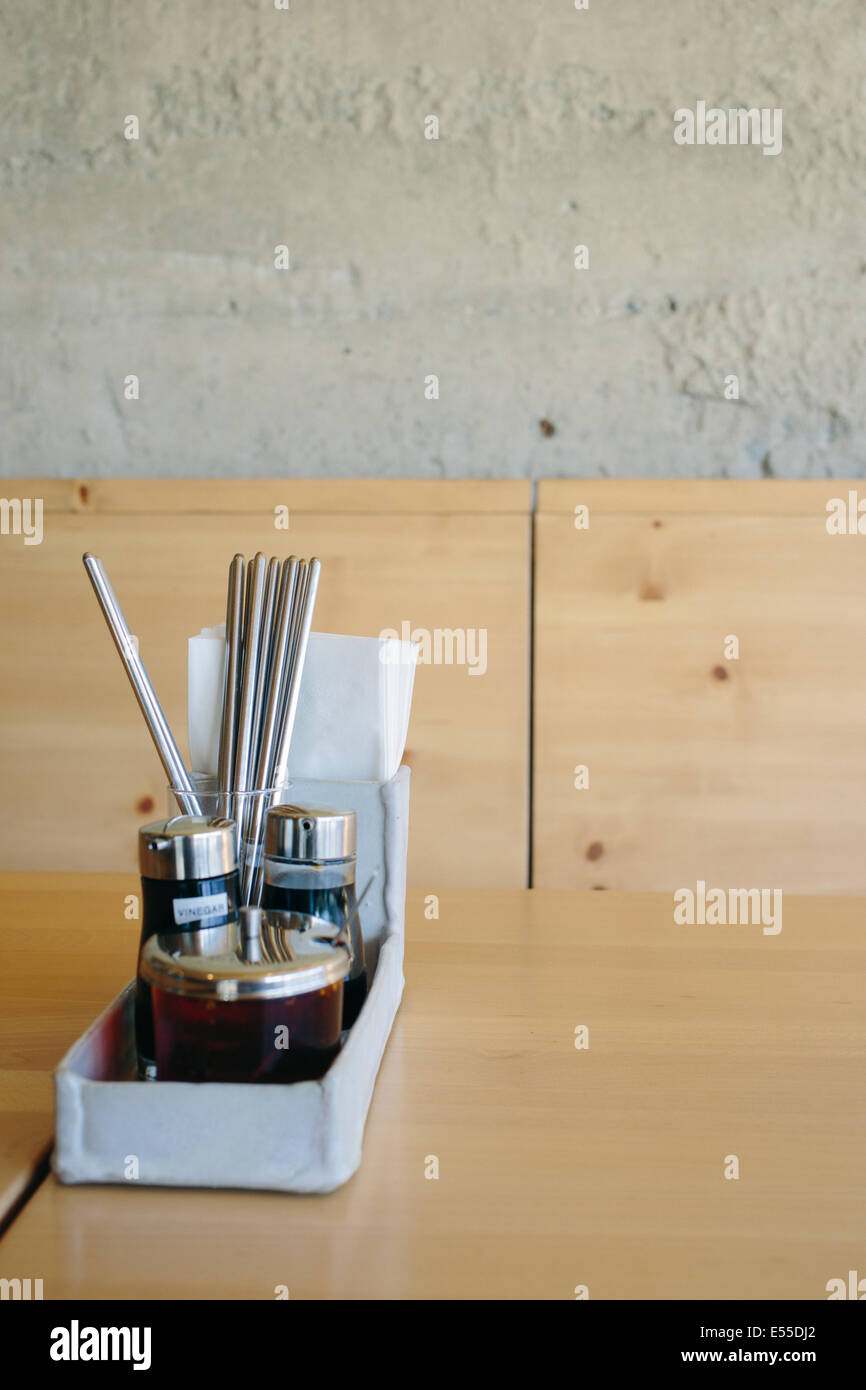Utensils and condiments on a wood table in a restaurant Stock Photo - Alamy
