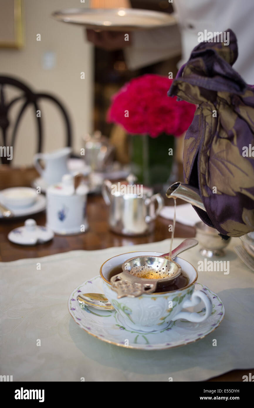Waiter pouring tea into tea cup with saucer Stock Photo - Alamy