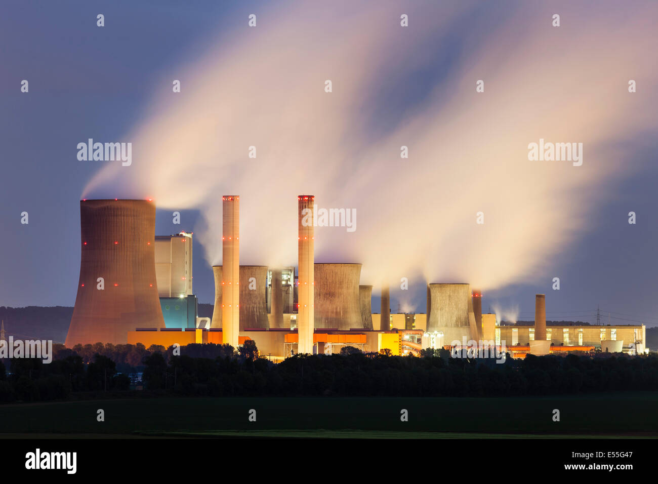 A coal-fired power station in the distance at night. The power station ...