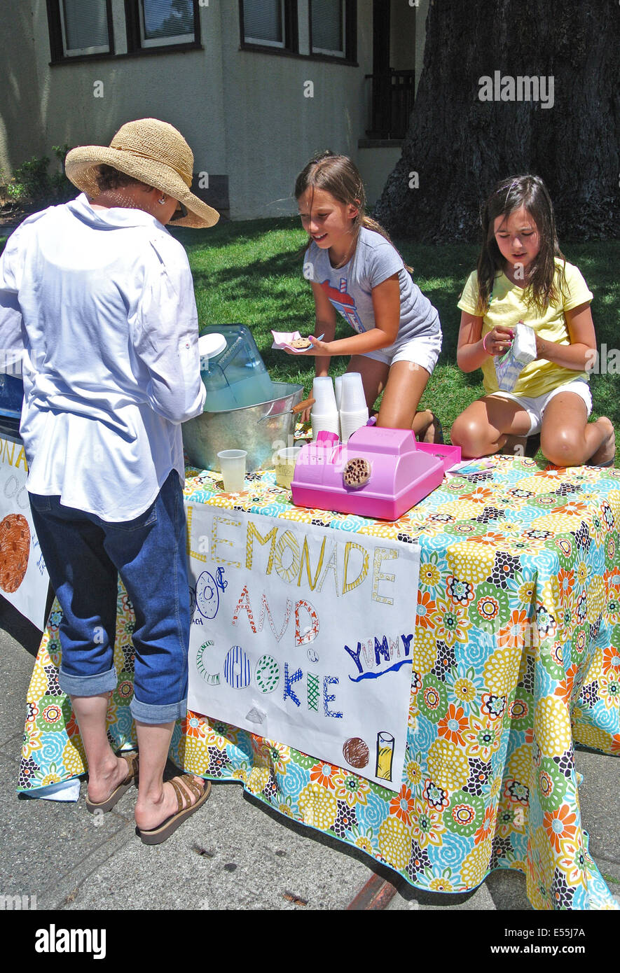 woman buys lemonade and cookies for two girls at lemonade stand Stock ...