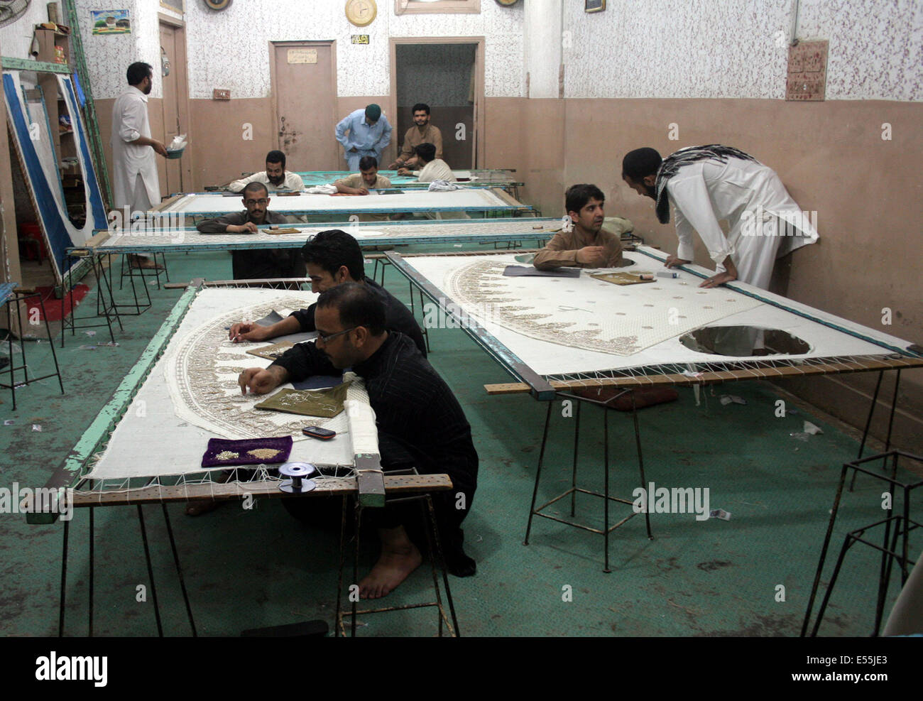 Peshawar, Pakistan. 21st July, 2014. Pakistani workers work on a ...