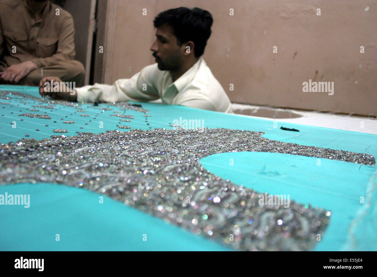 Peshawar, Pakistan. 21st July, 2014. Pakistani workers work on a ...