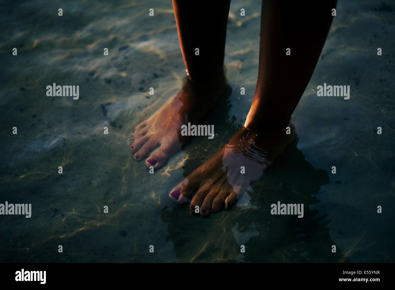 Woman standing barefoot in the water Stock Photo - Alamy