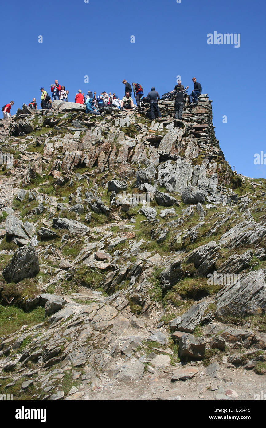 Walkers crowd onto the summit cairn of Mount Snowdon on a warm summer's ...