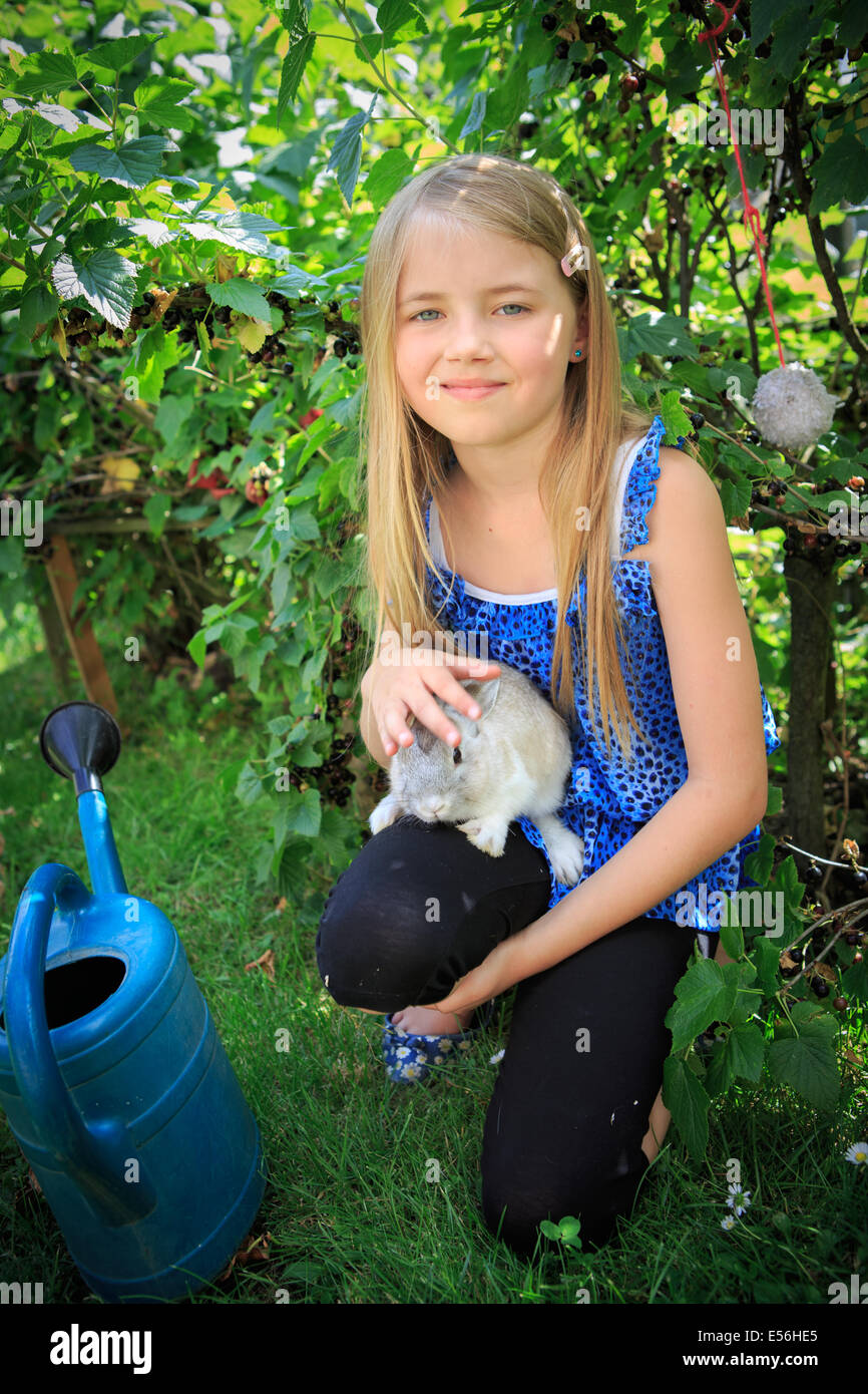 Teenage girl playing with a rabbit in the backyard Stock Photo - Alamy