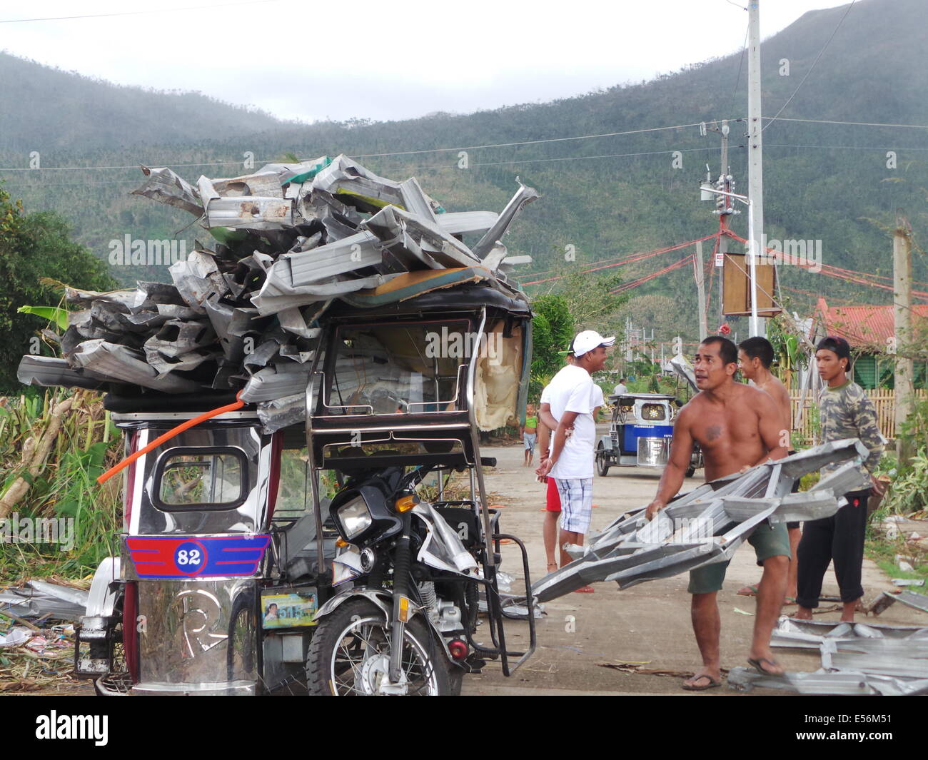 Group of men clearing up the metal roofing of their wrecked homes at ...