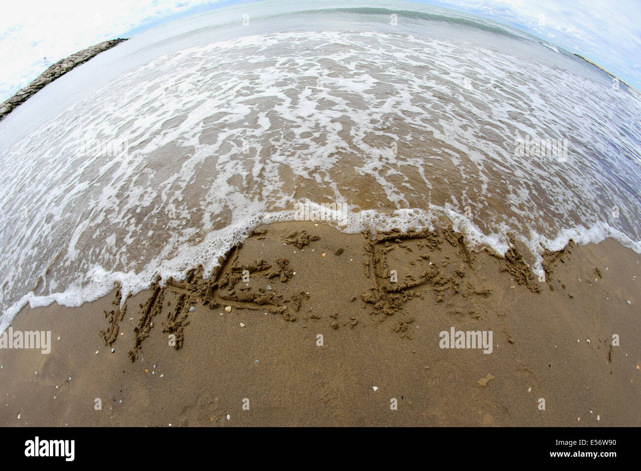 sea wave clears the words THE END on the beach photographed with ...