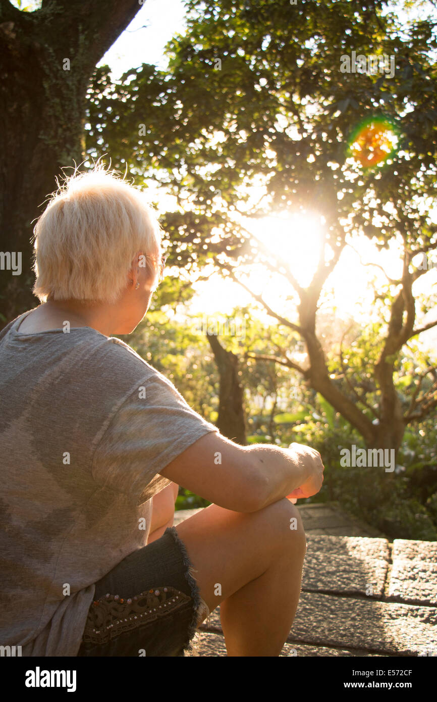 Mature woman of Chinese ethnicity taking a break during a hike up ...