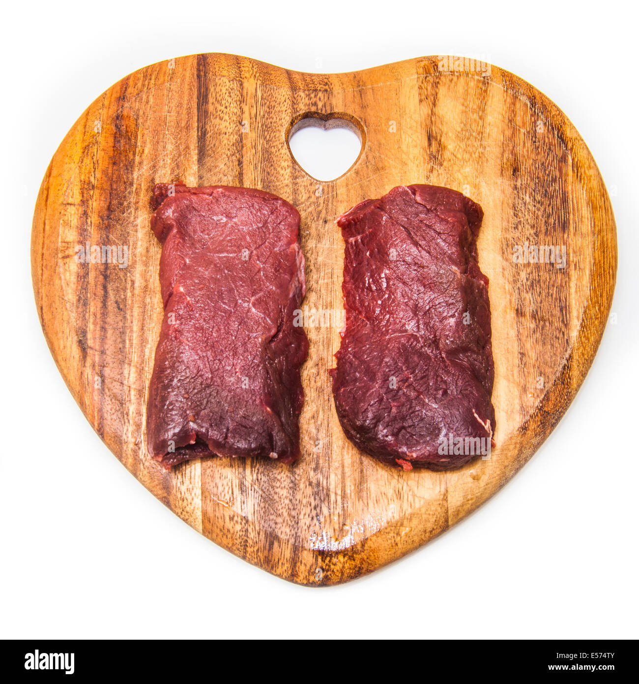 Camel meat steaks on a wooden chopping board isolated on a white studio ...