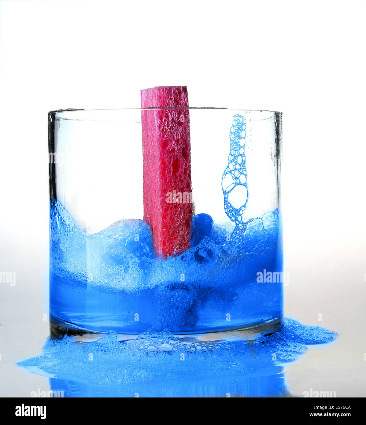Pink Sponge falling into Blue colored Soapy Water in Glass Bowl Stock ...