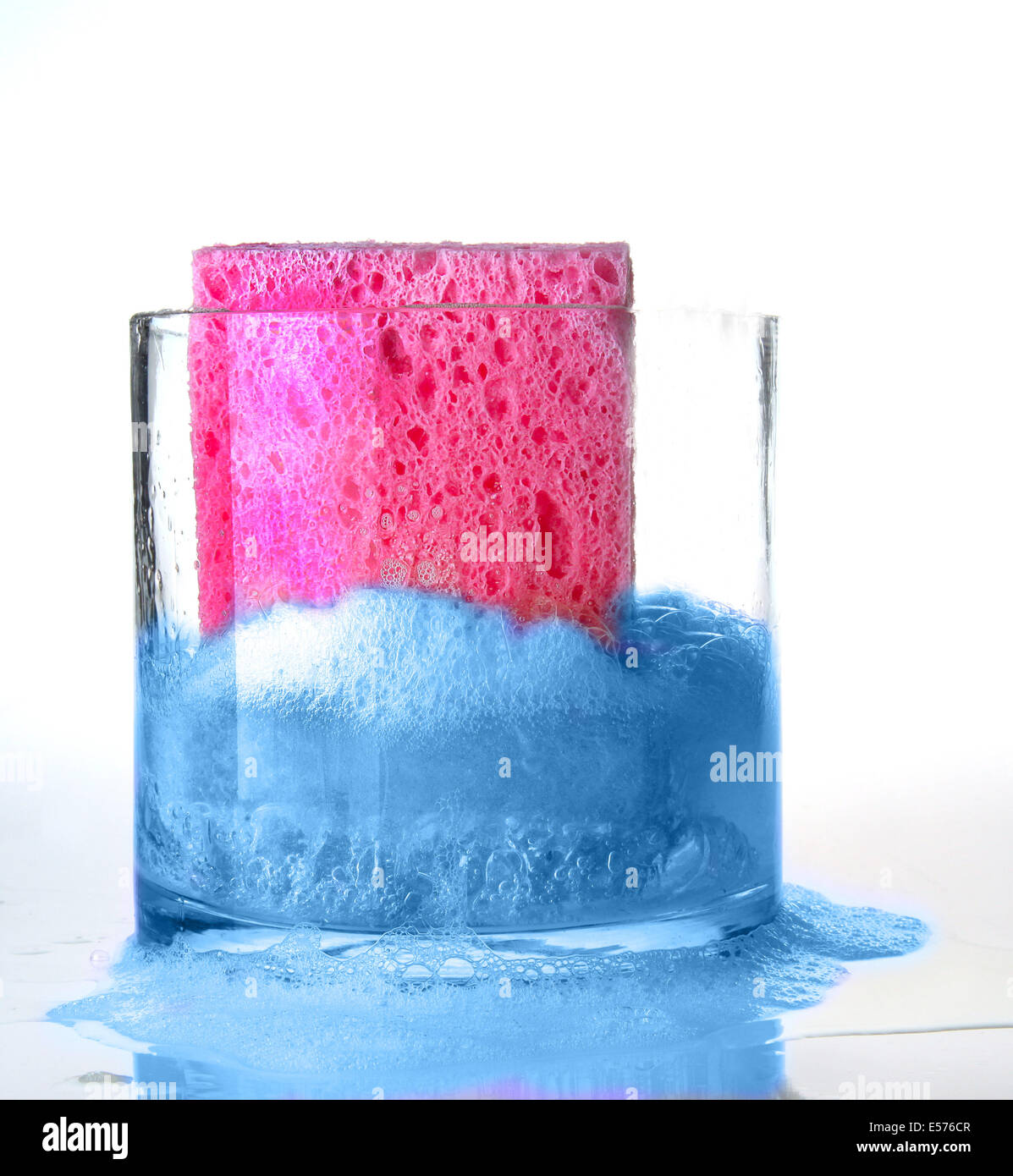 Pink Sponge falling into Blue colored Soapy Water in Glass Bowl Stock ...