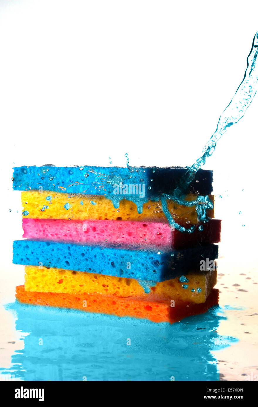 Multi Colored Sponges Stacked on top of one another with Blue Splash ...