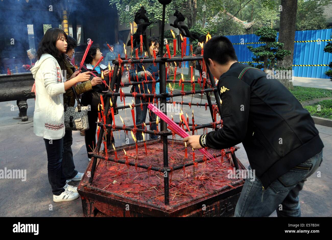 XINDU, CHINA: Faithful Buddhist visitors light incense sticks from a ...