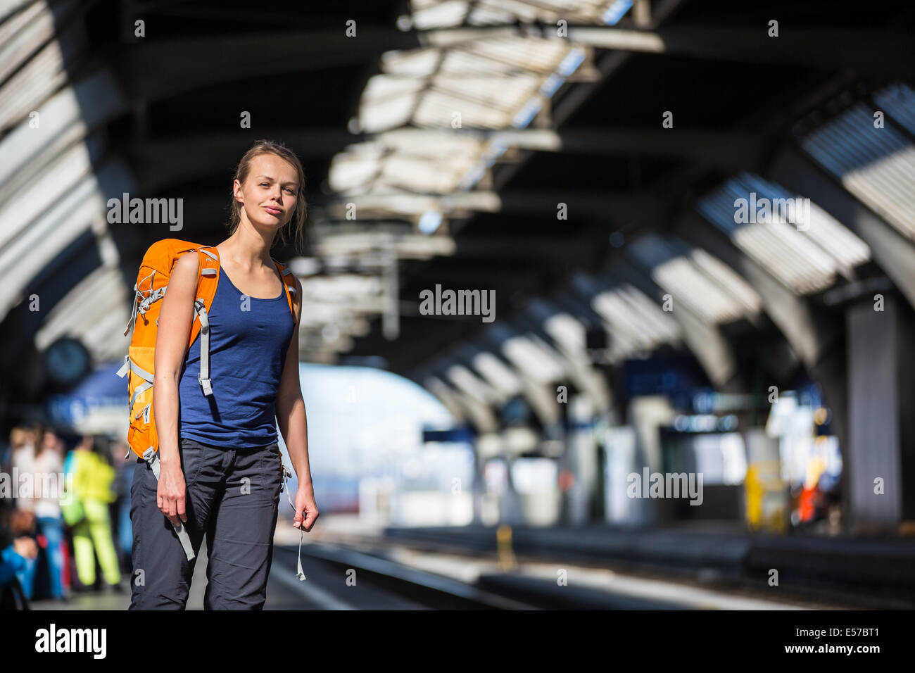 Pretty, young woman in a trainstation, waiting for her train, boarding ...