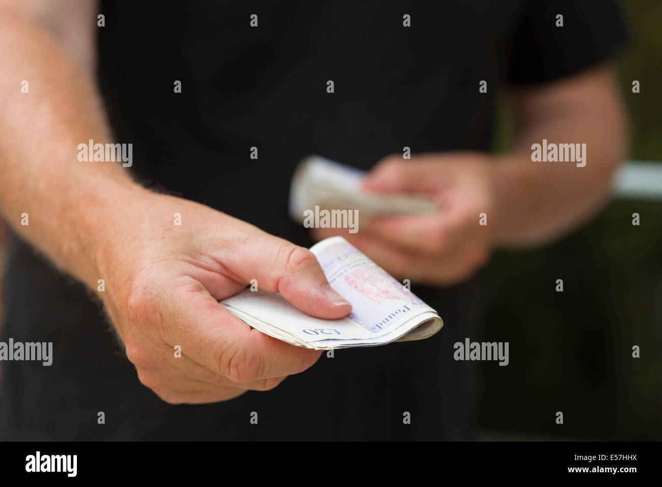 Handing over UK cash notes. Counting money maybe about to pay in cash ...