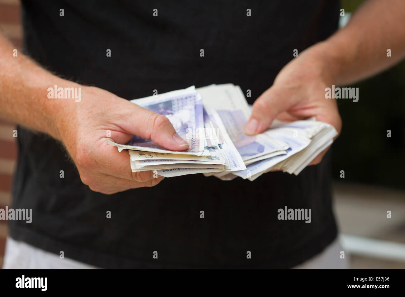 Handing over UK cash notes. Counting money maybe about to pay in cash ...