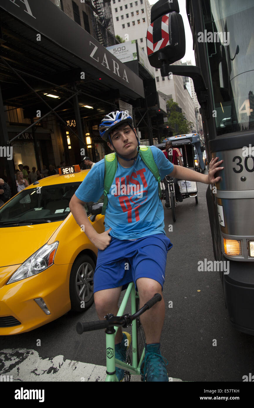 Young bicyclist in traffic in Manhattan waiting for the light to change ...