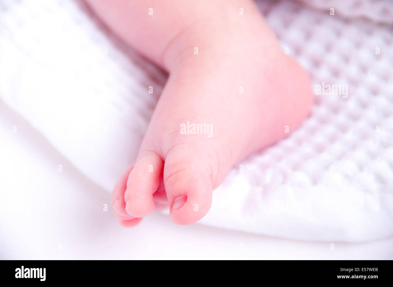 Newborn baby stretching out in a light and airy nursery moses basket ...
