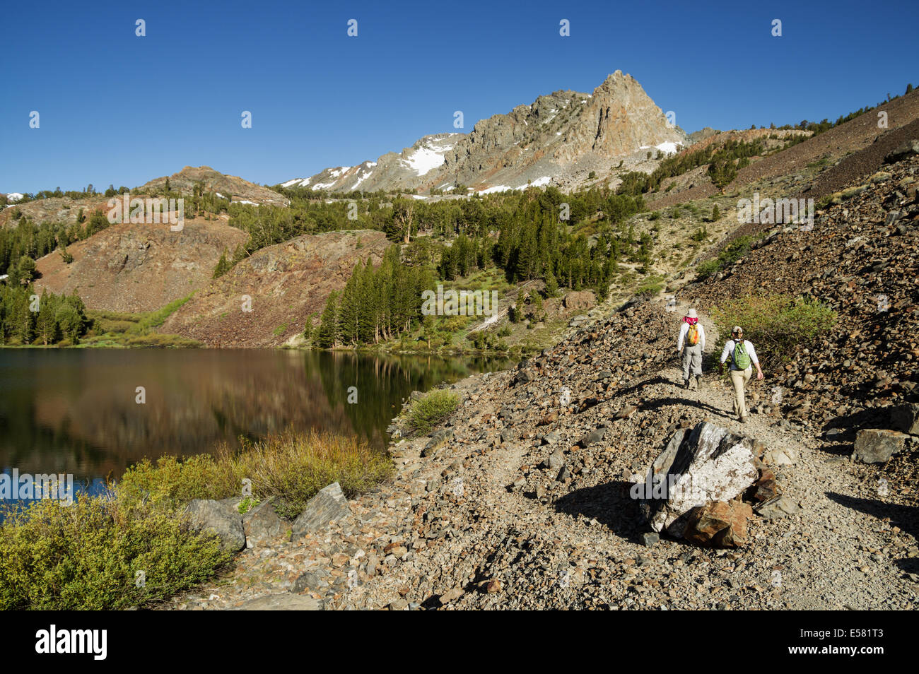 a couple hiking past Blue Lake in the Sierra Nevada Mountains Stock ...