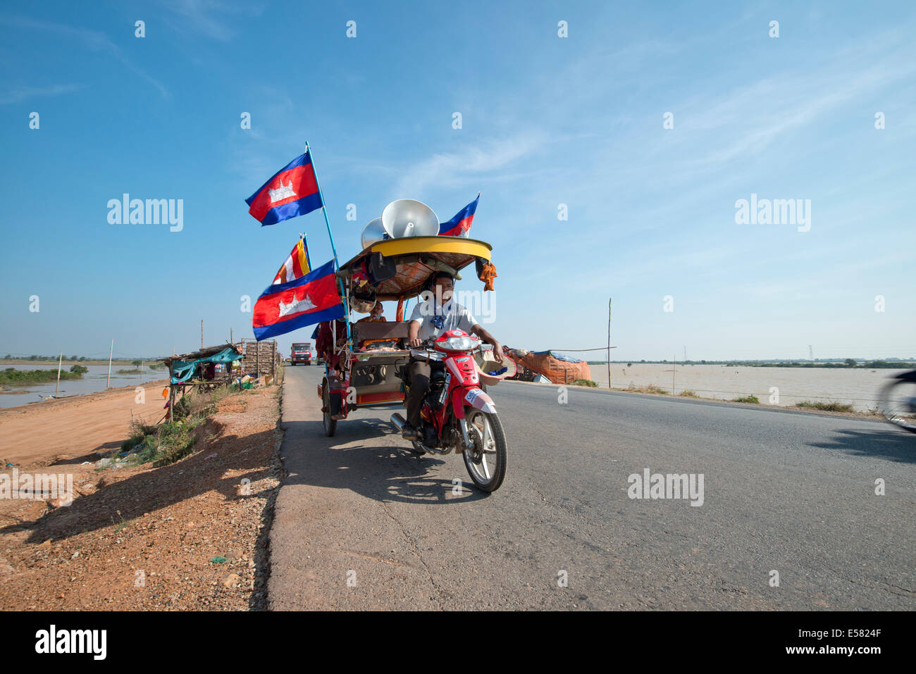 Cambodian monks and novices on a tuktuk with Buddhist flags and ...