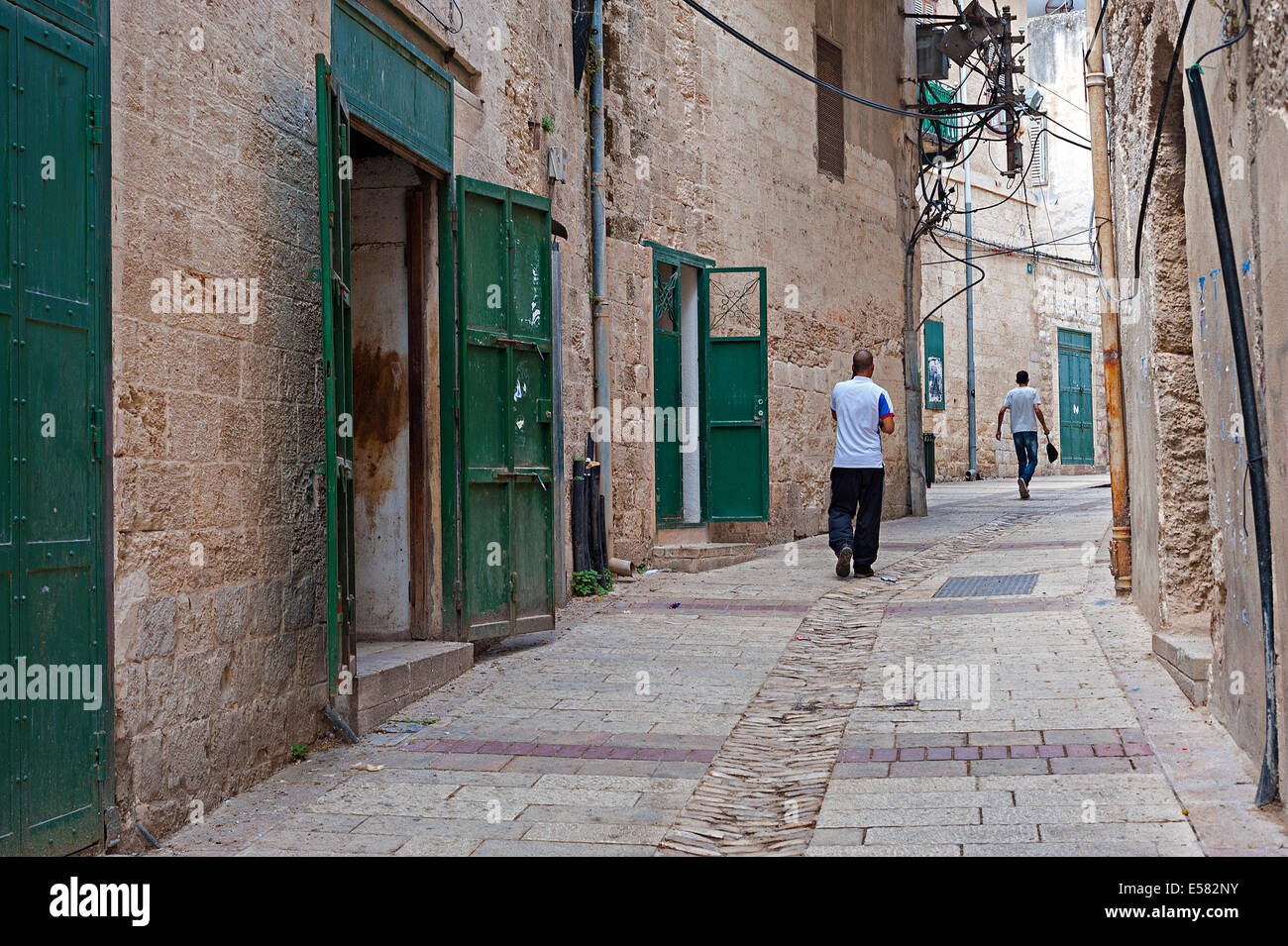 Two men walking down an alleyway in the old city, Nazareth, Israel ...