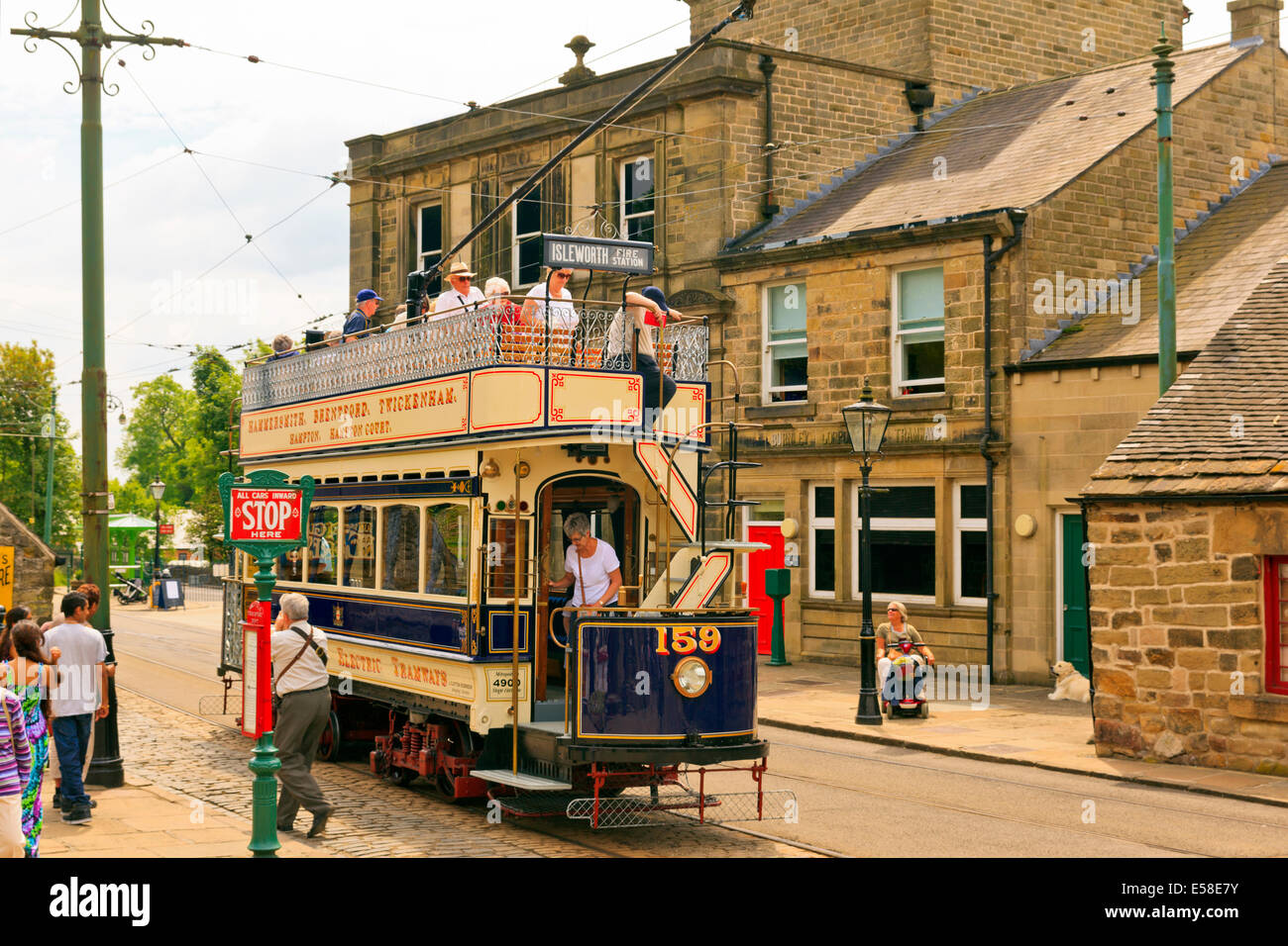 Open top electric tram operating in street scene from Crich Tramway ...