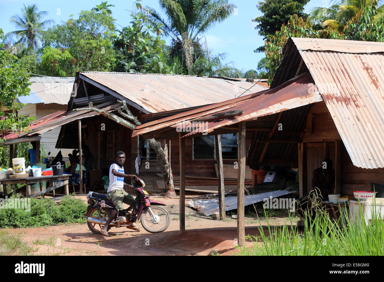 Man on motorbike in a poor village of the maroon tribe in the ...